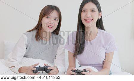 Couple Of Amusing Young Women Holding Controllers And Playing Video ...