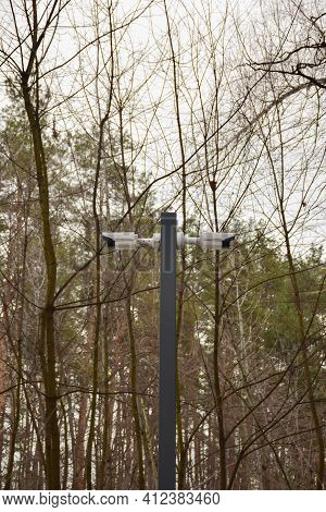 A Video Surveillance Camera Is Installed On A Pole In The Park ...