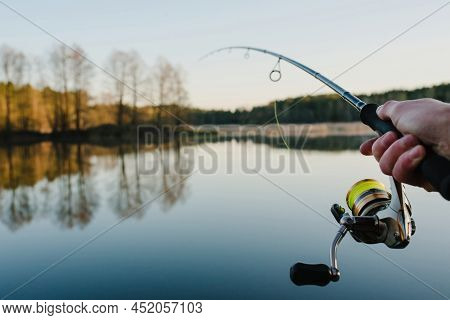 Fishing. Fisherman With Rod, Spinning Reel On The River Bank. Fishing ...