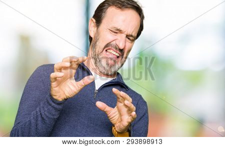 Middle age handsome man wearing a sweater disgusted expression ...