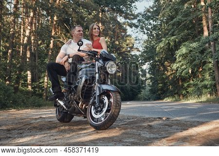 Young Beautiful Couple Talking And Having Fun, Sitting On A Motorcycle ...