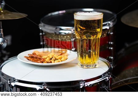 Glass Of Light Beer With Salty Snacks On Professional Drum Set Closeup ...