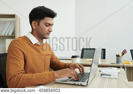 Serious Young Indian Businessman Working On Laptop At Office Desk ...