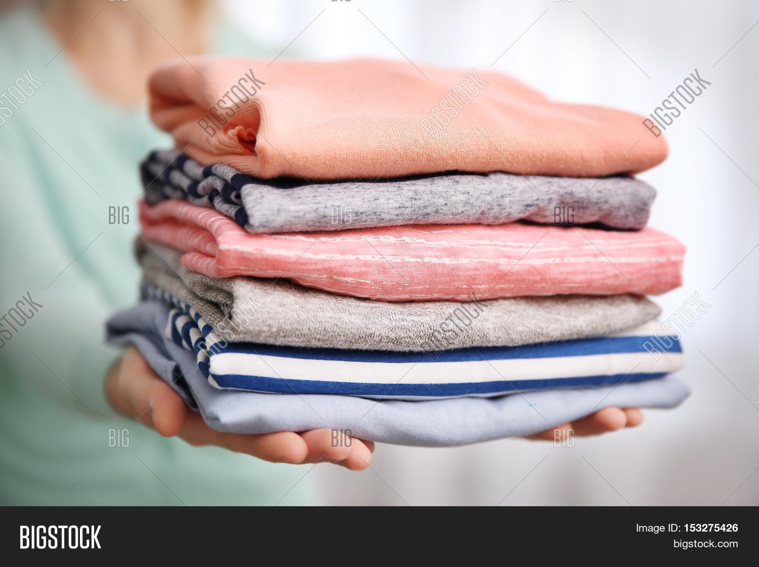 Woman holding folded clothes in hands, closeup Stock Photo & Stock ...