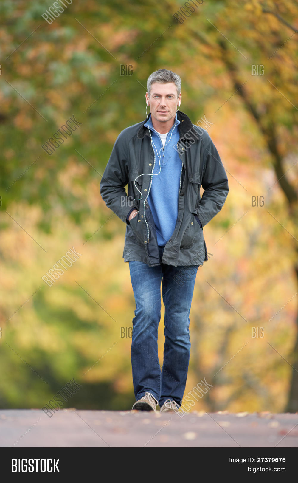 Hombre caminando a través de otoño Parque escuchando MP3 Player Fotos ...