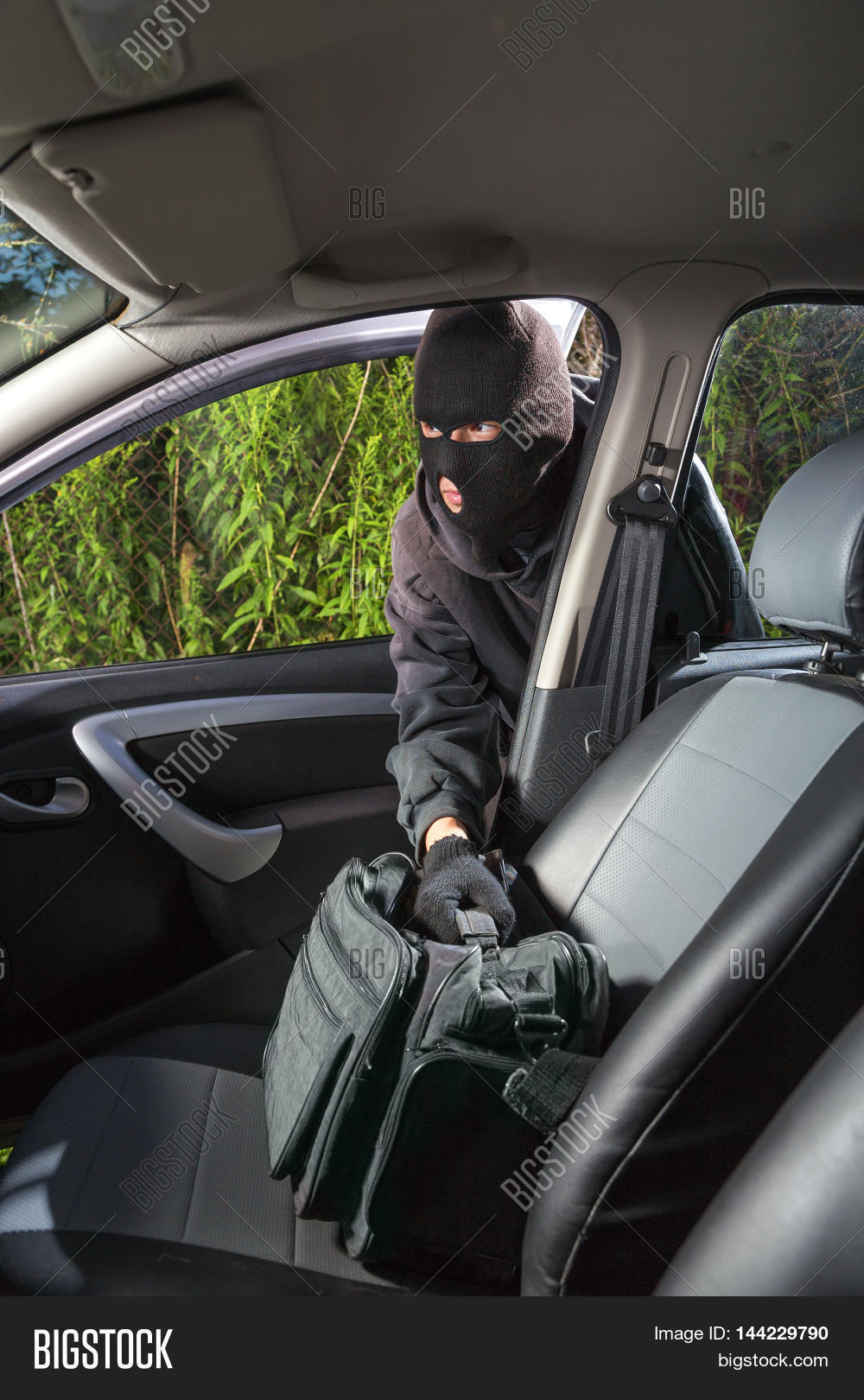 Thief in a mask stealing a bag from the car Stock Photo & Stock Images ...