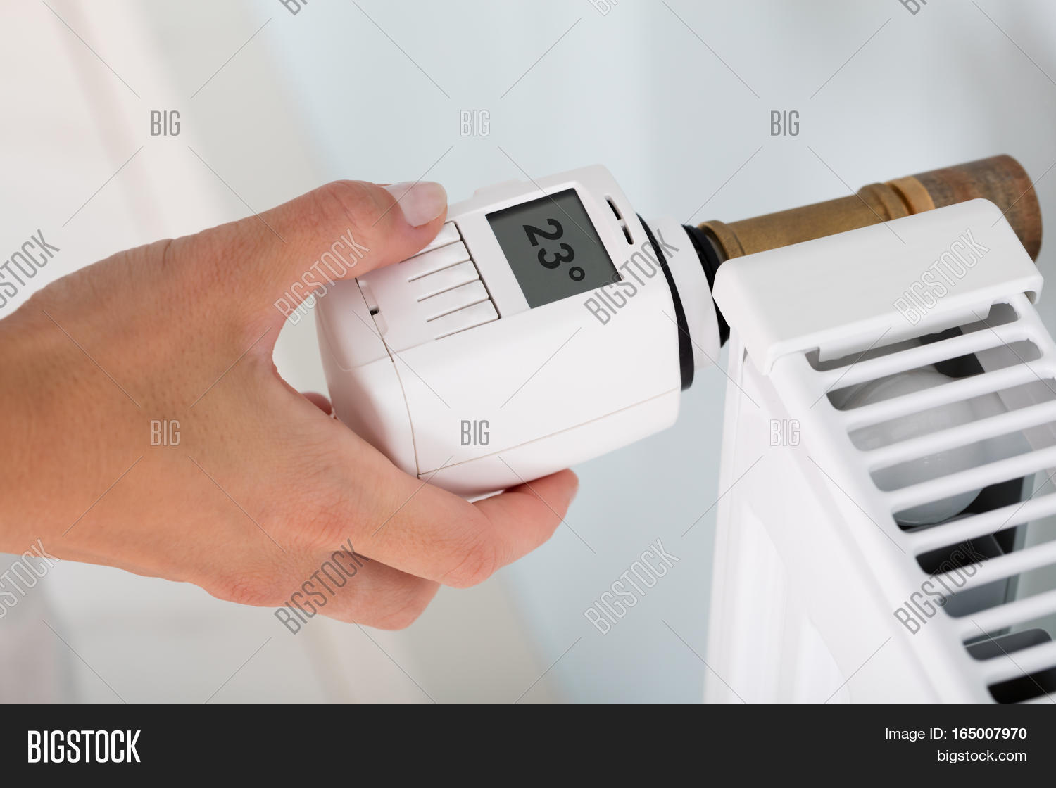 Person's Hand Adjusting Temperature On Thermostat To Control Heat In ...