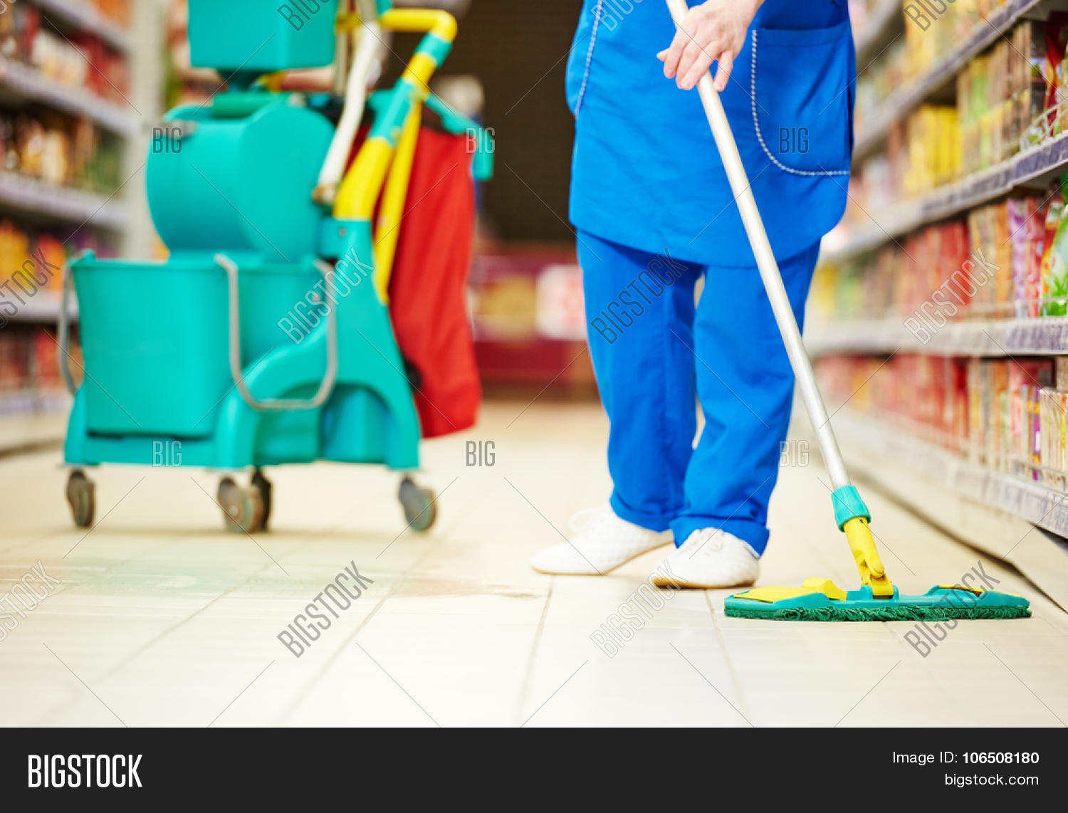 Female cleaner worker in uniform with mop cleaning the floor of ...
