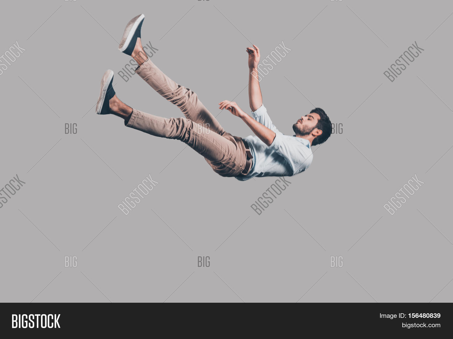 Man falling down. Mid-air shot of handsome young man falling against ...
